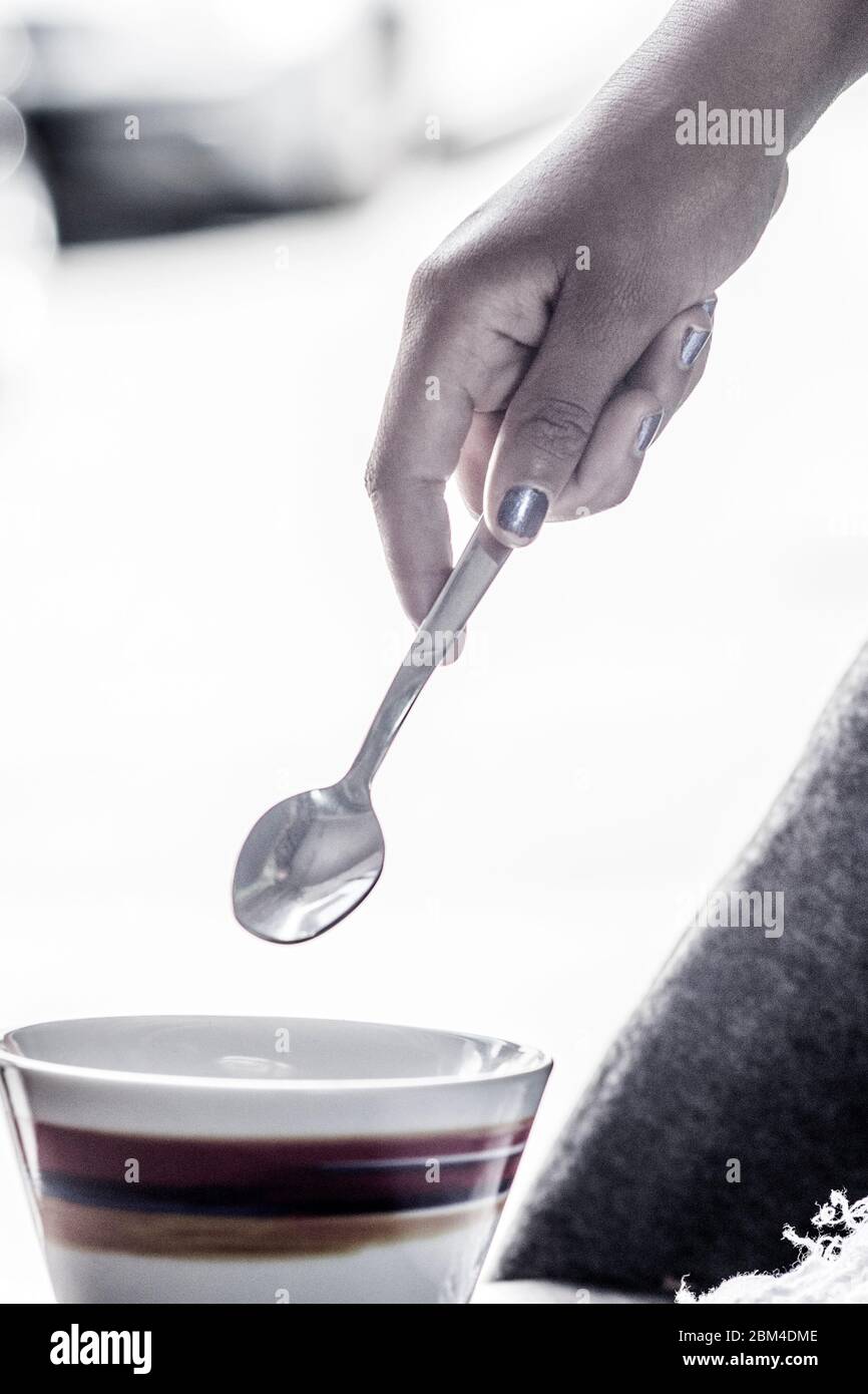 girl holds a small spoon over a mug with colorful decorations Stock ...