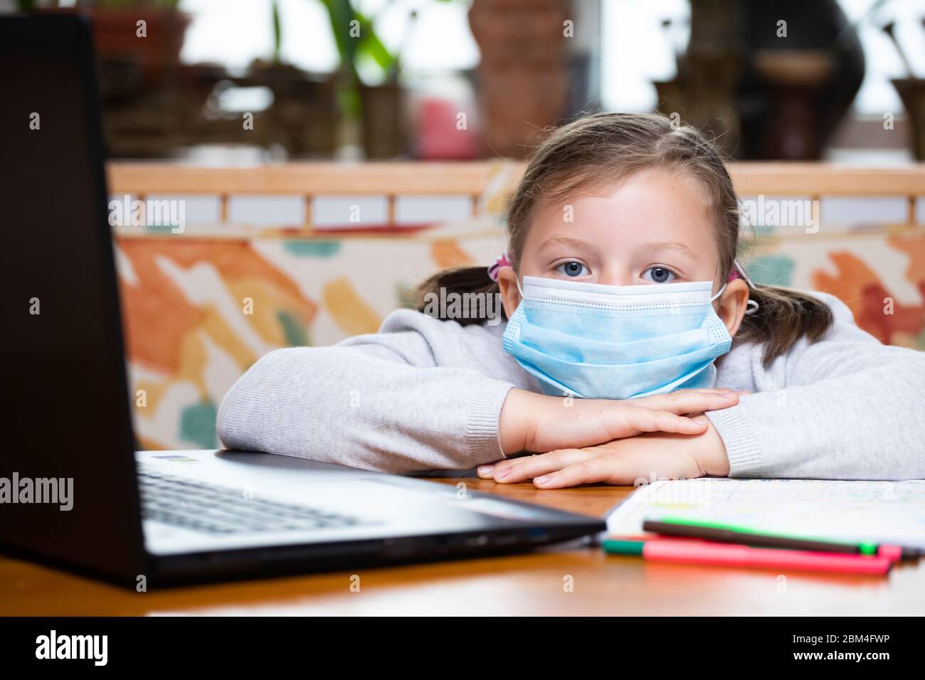 Distance learning-online education. School girl with face mask watching ...