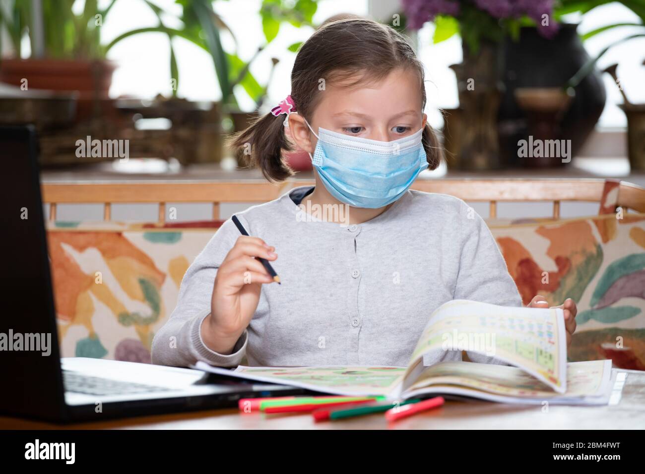 Distance learning-online education. School girl with face mask watching ...