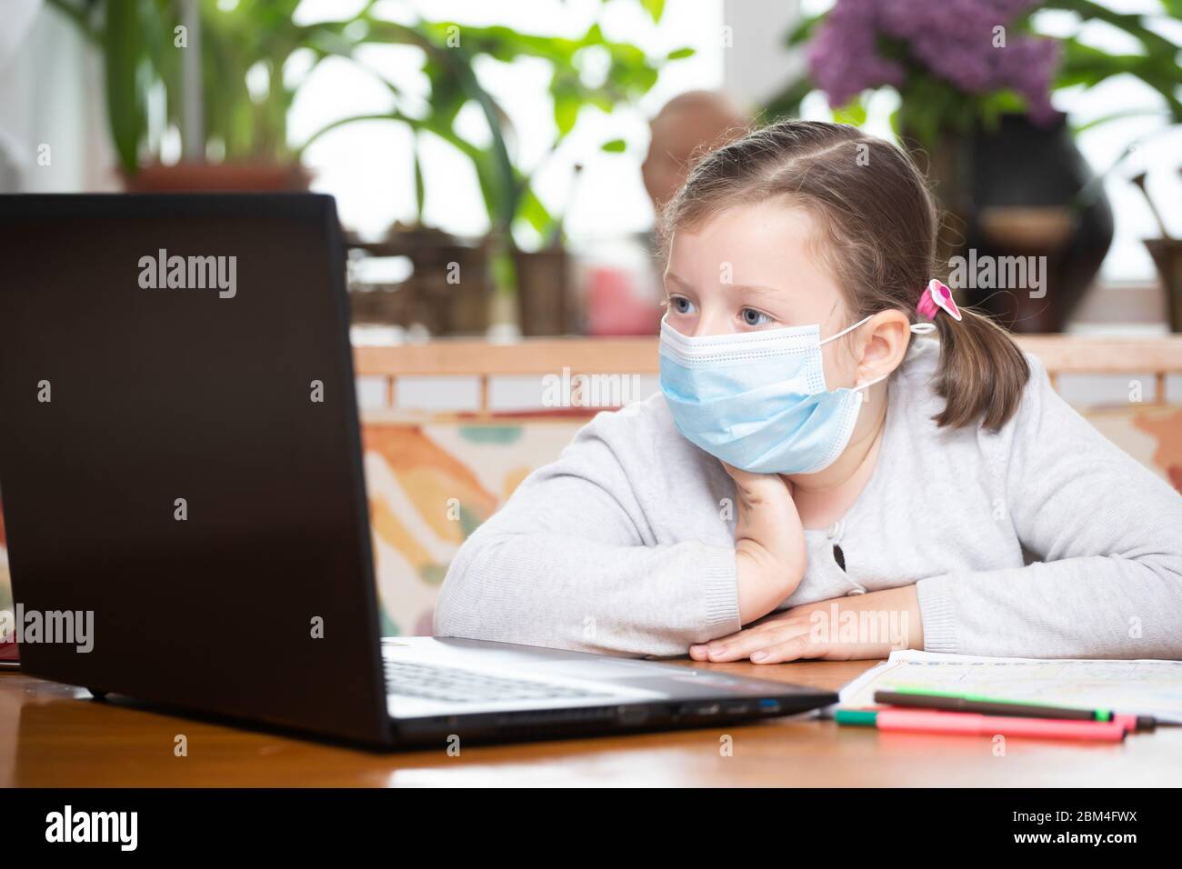 Distance learning-online education. School girl with face mask watching ...