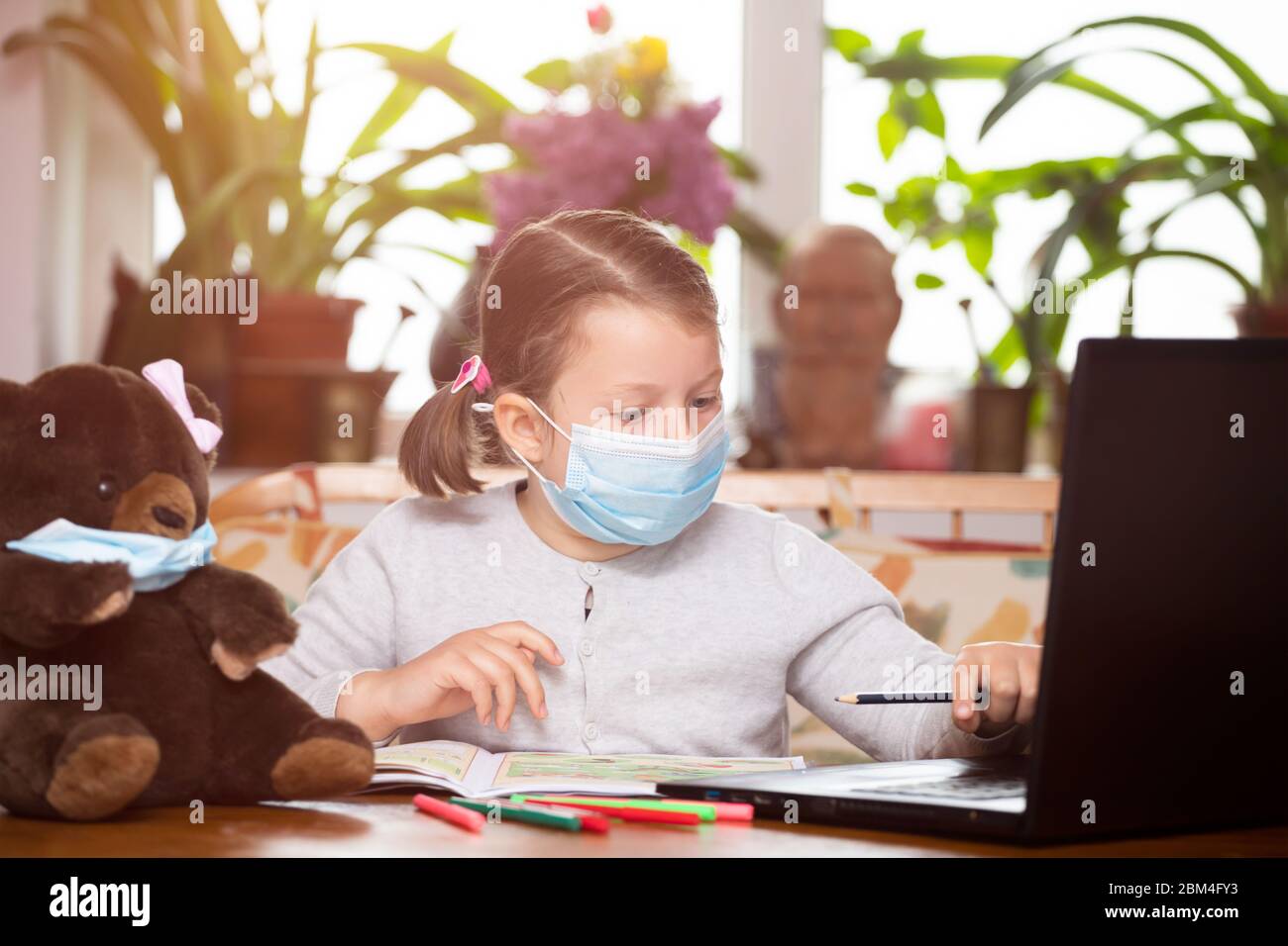 Distance learning-online education. School girl with face mask watching ...