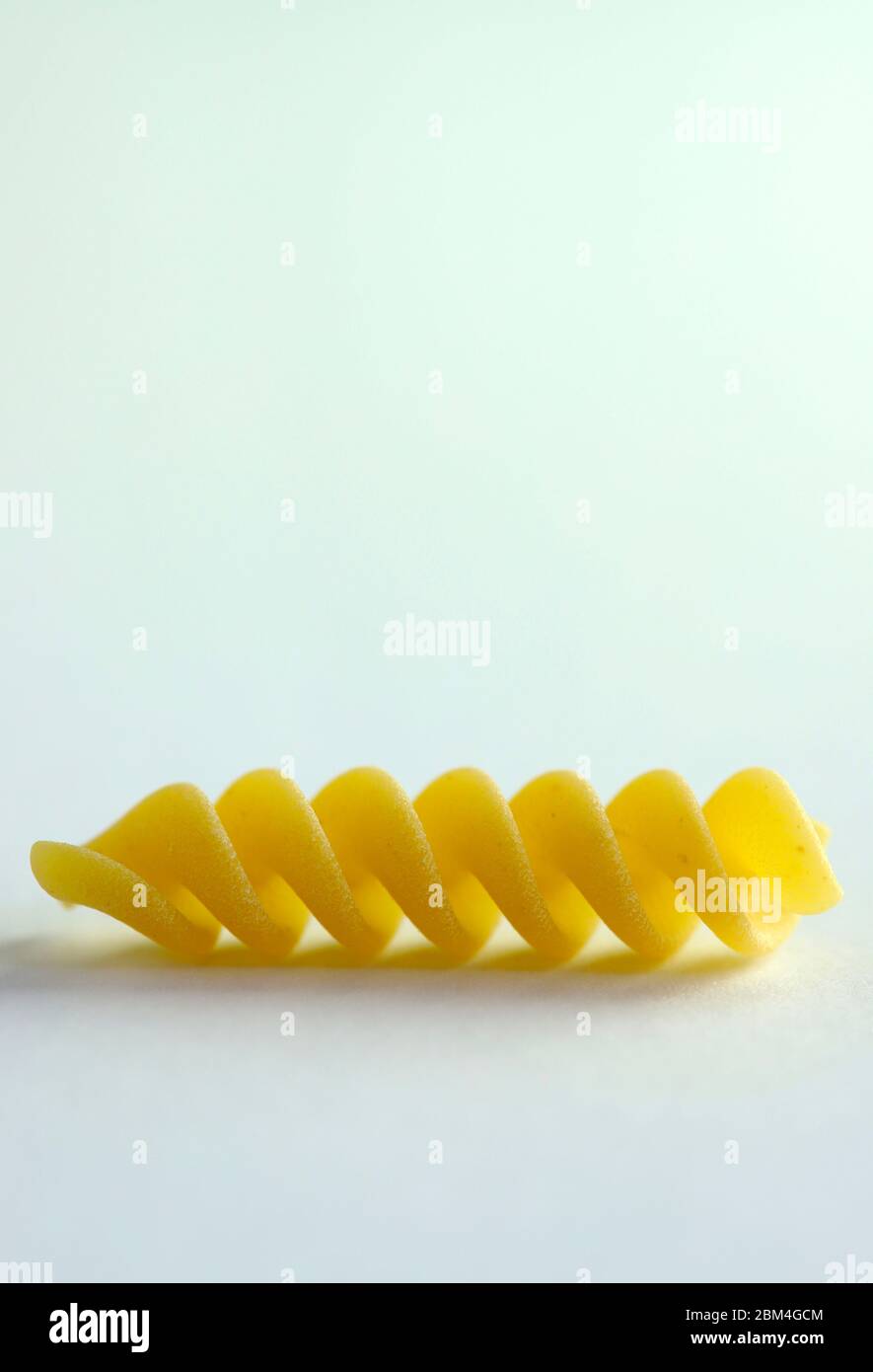 Italian food concept. One piece of fusilli pasta isolated on white ...