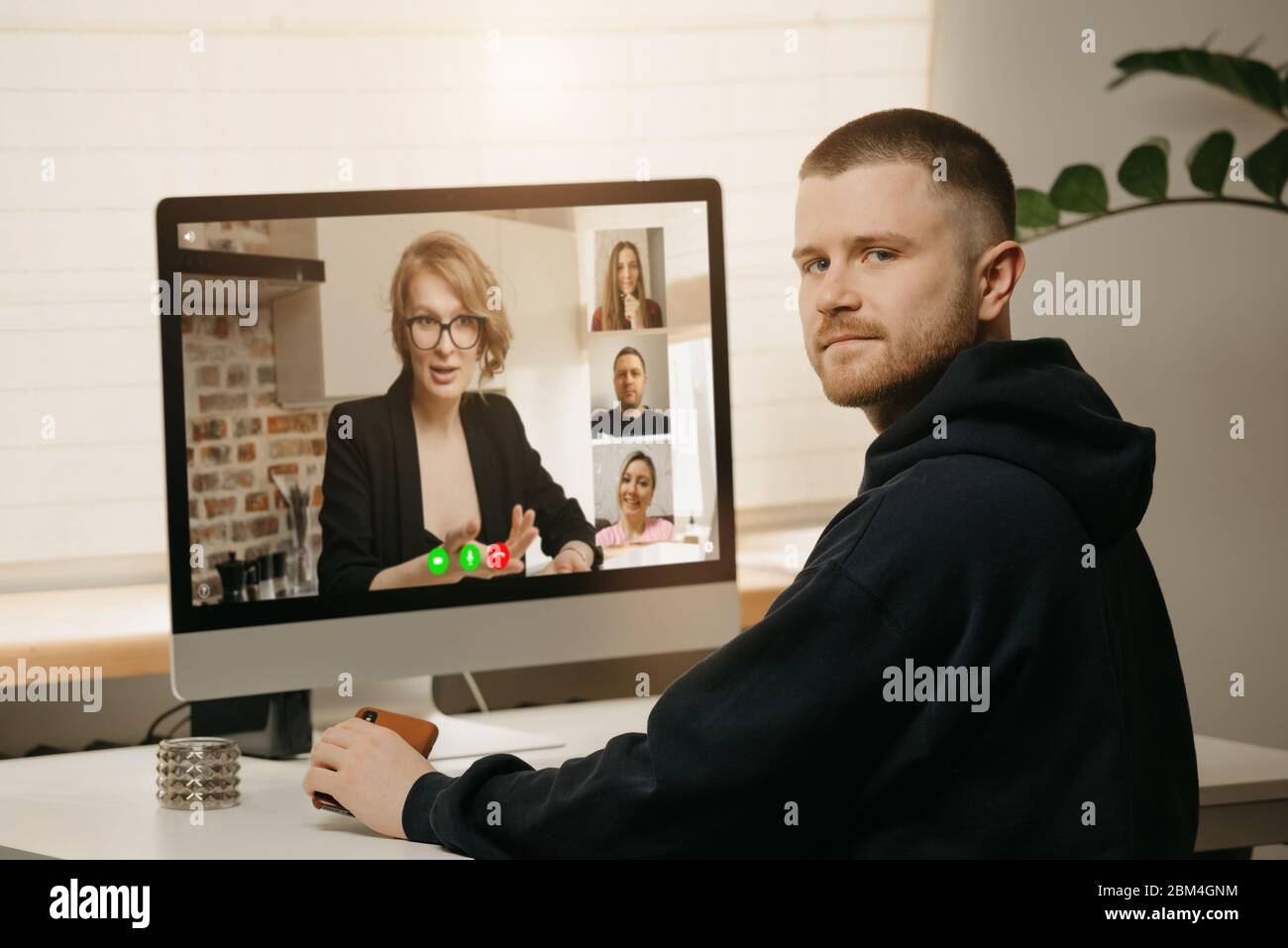 Remote work. A back view of a man during a video call with his ...