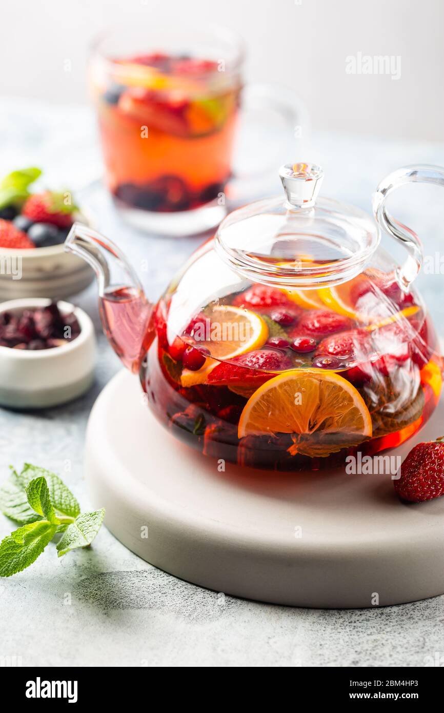 Fruit red tea with berries in glass teapot on white background Stock ...