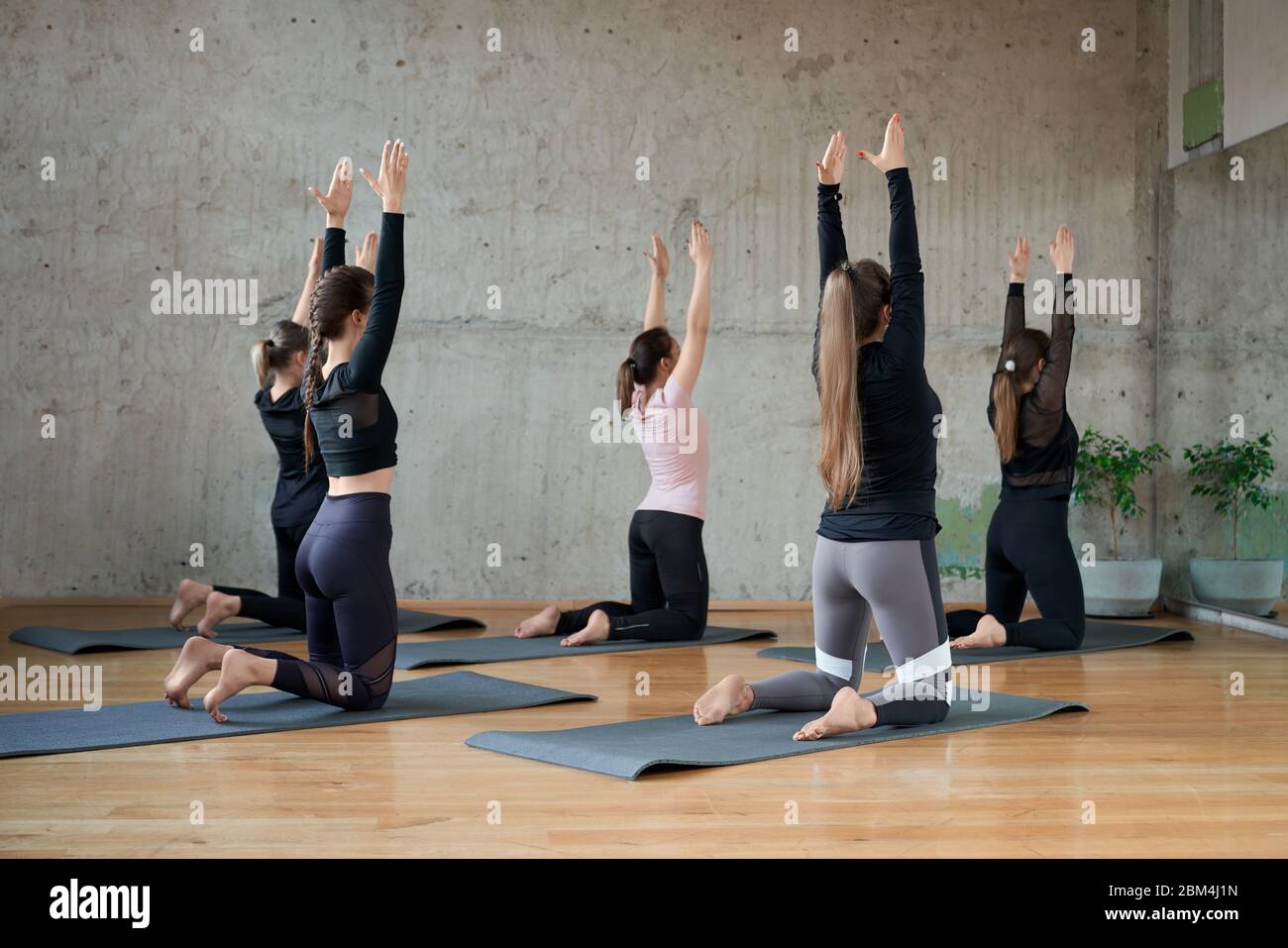 Back view of young fitnesswomen in sportswear practicing yoga pose ...