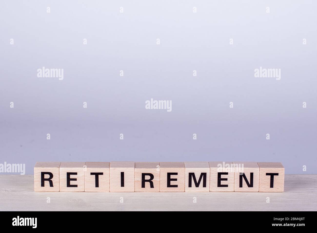 wooden cubes building the word Retirement, white background and board ...