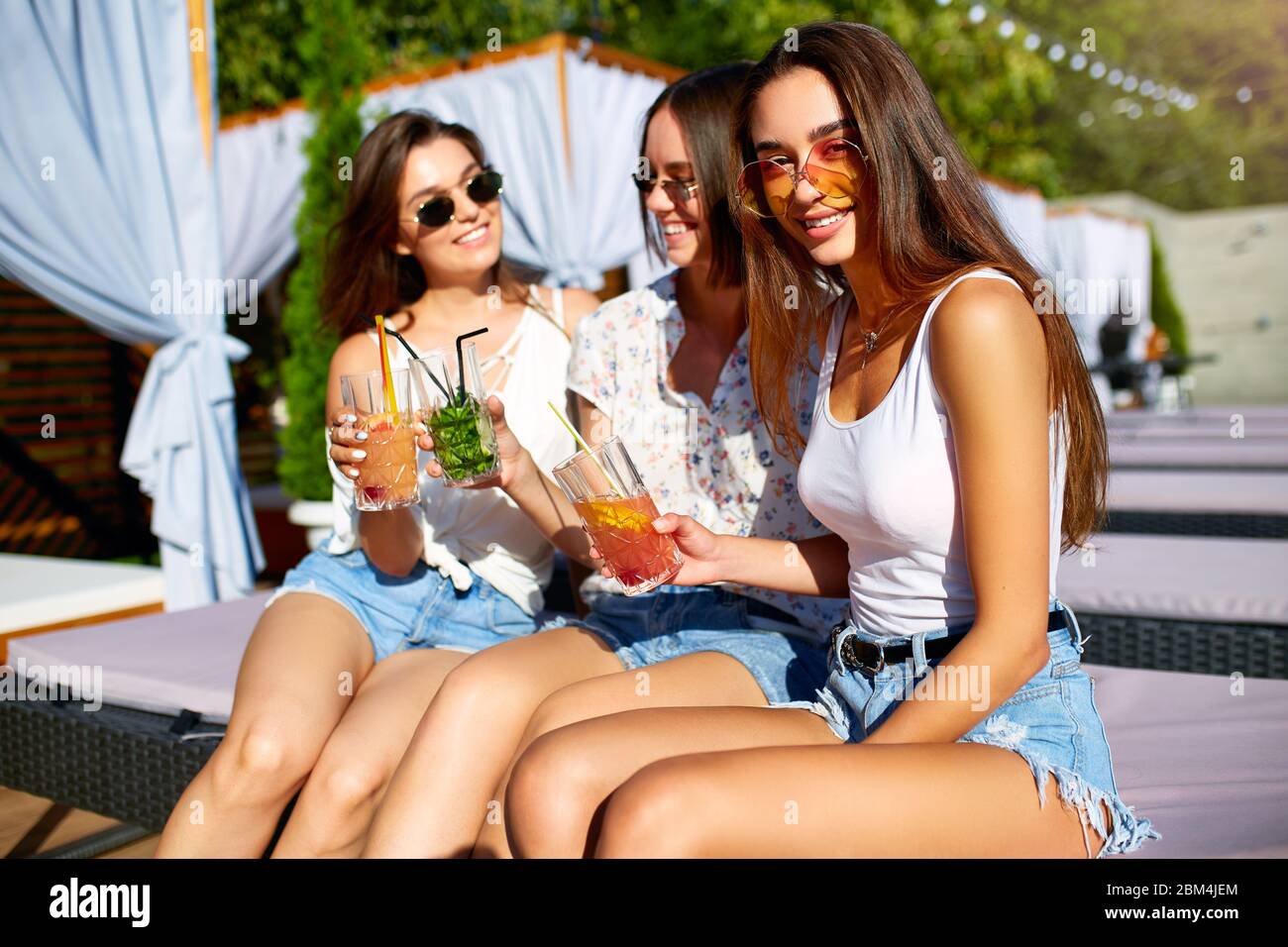 Group Of Friends Having Fun At Poolside Party Clinking Glasses With