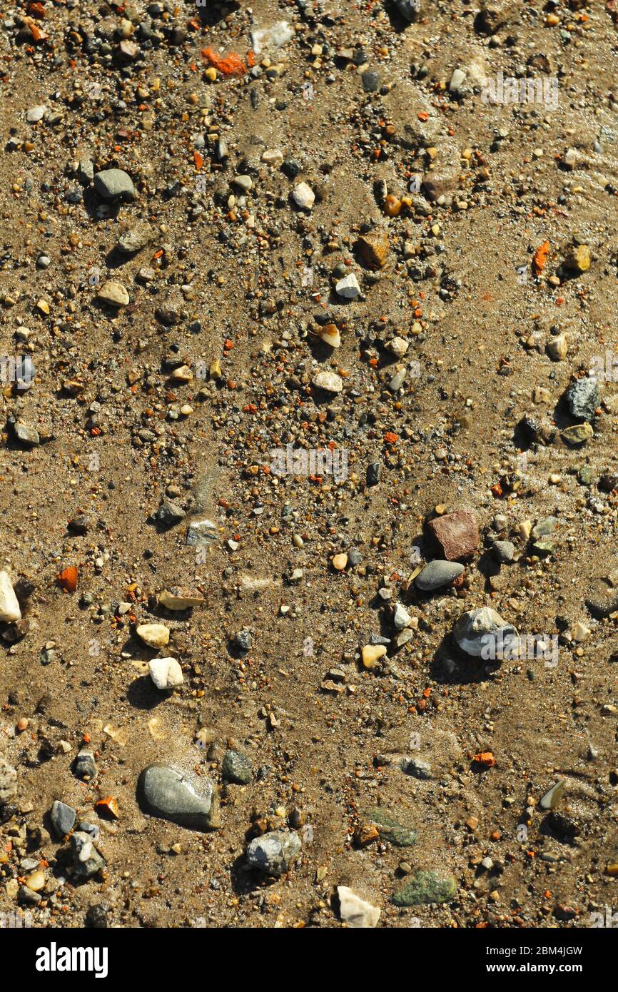Small stones and sand. The natural texture of the soil. Shore of a ...