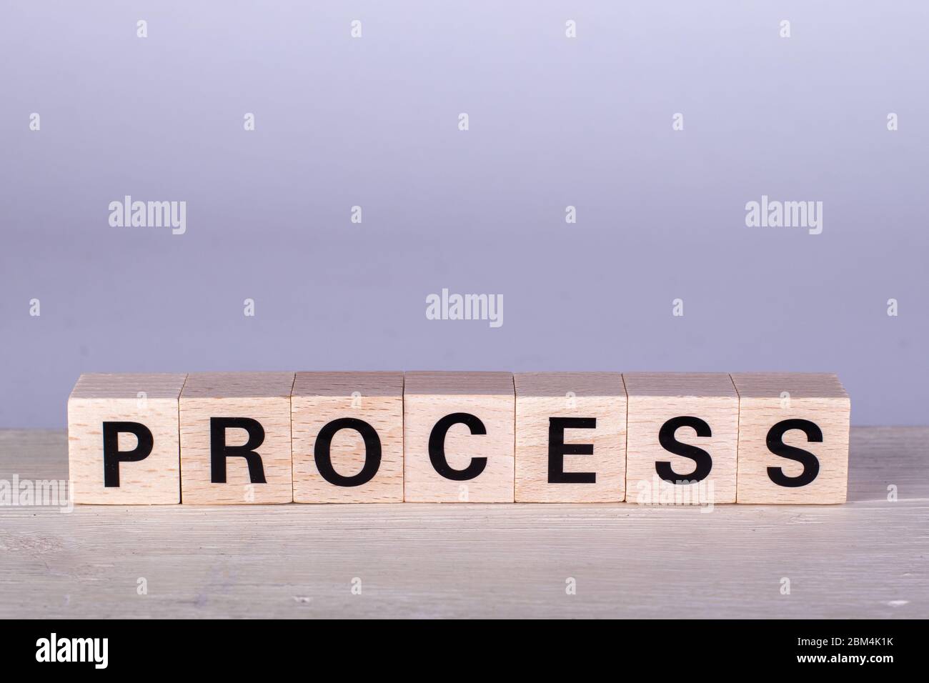 wooden cubes building the word Process, white background and board ...