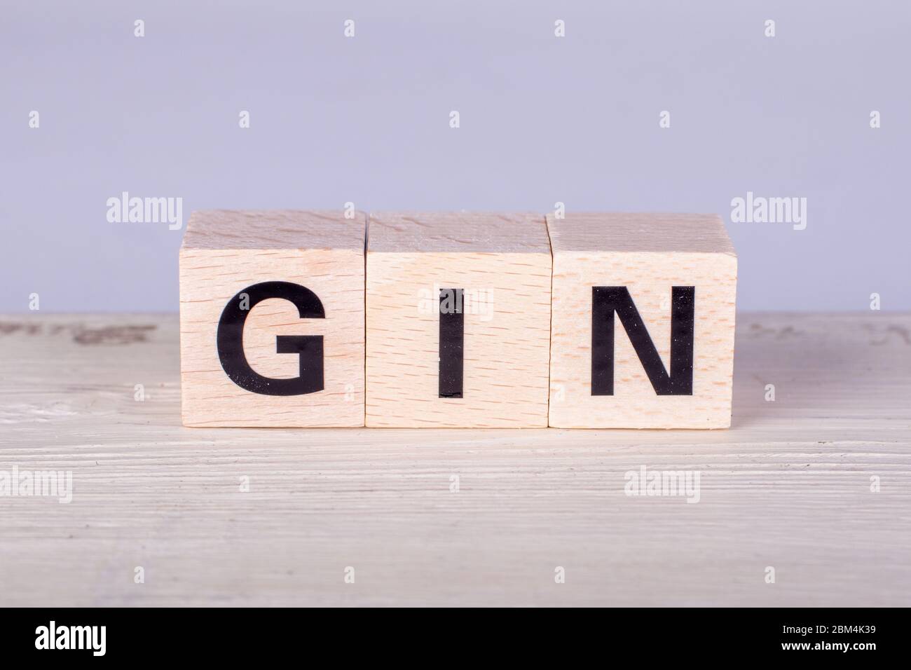 wooden cubes building the word GIN, white background and board Stock ...