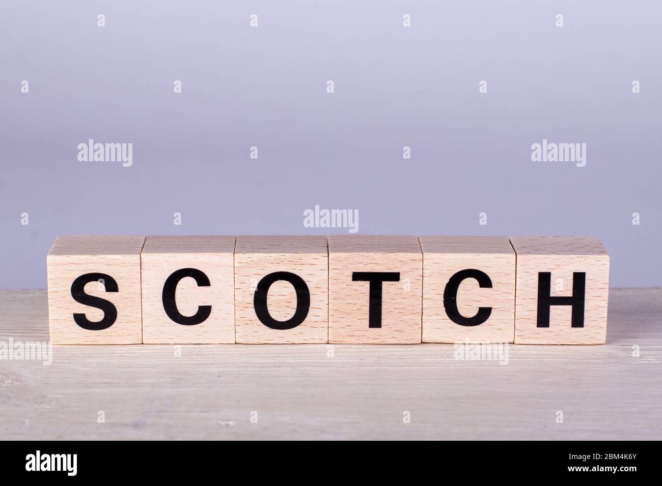 wooden cubes building the word Scotch, white background and board Stock ...