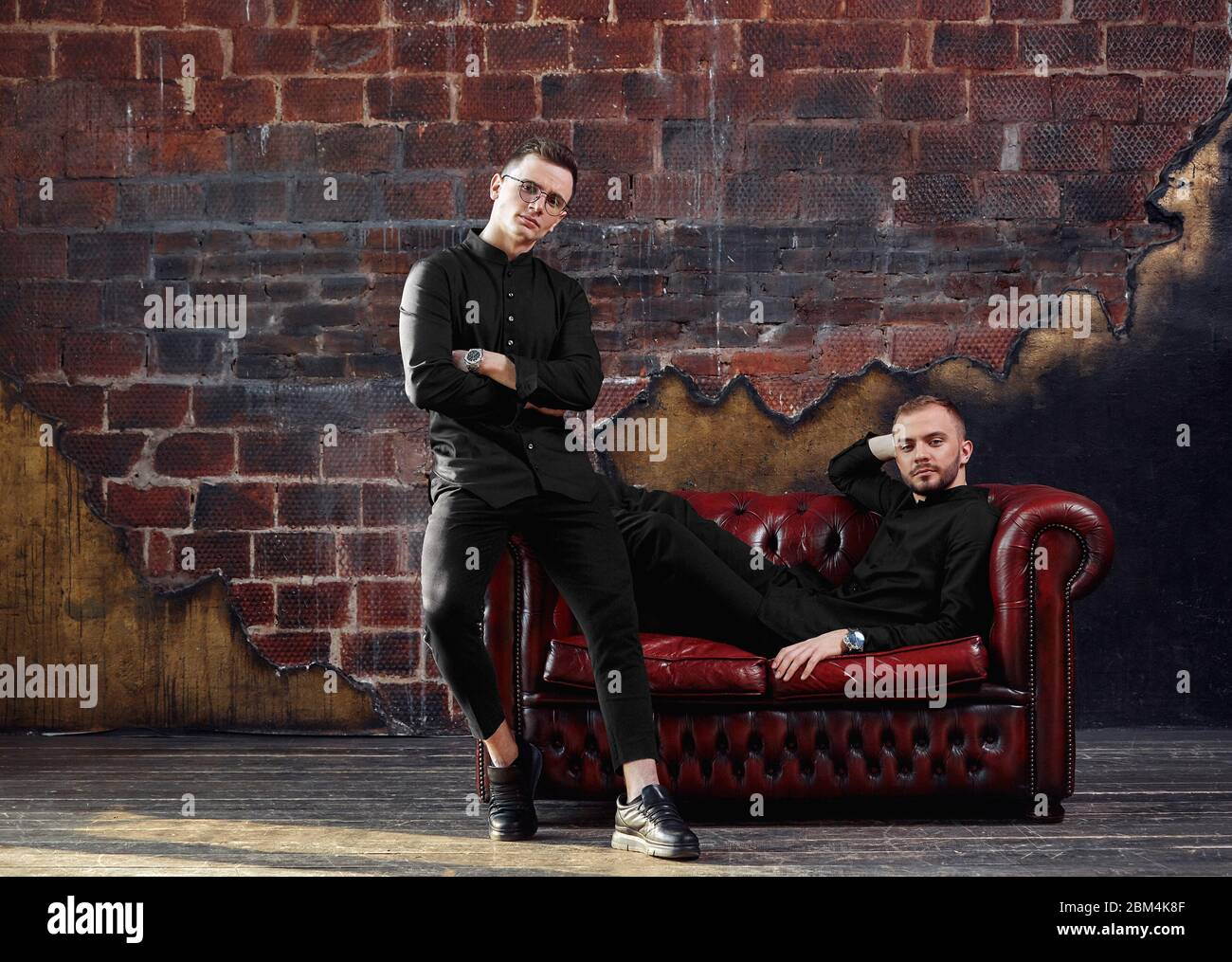 Two brothers friends are sitting on a sofa in the living room. Concept ...