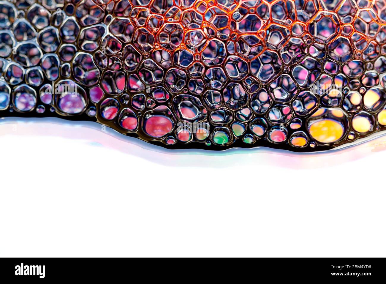 Multi-coloured soap foam background texture with white copy space below ...