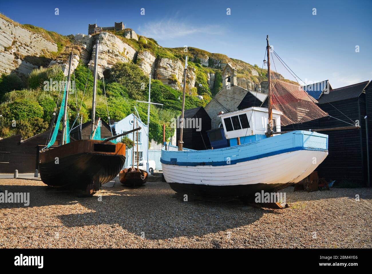 Boats among historic net huts in Hastings harbour, UK Stock Photo - Alamy