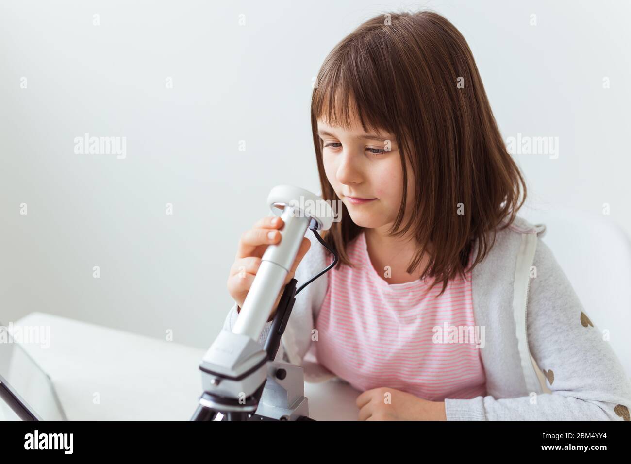 Child girl in science class using digital microscope. Technologies ...