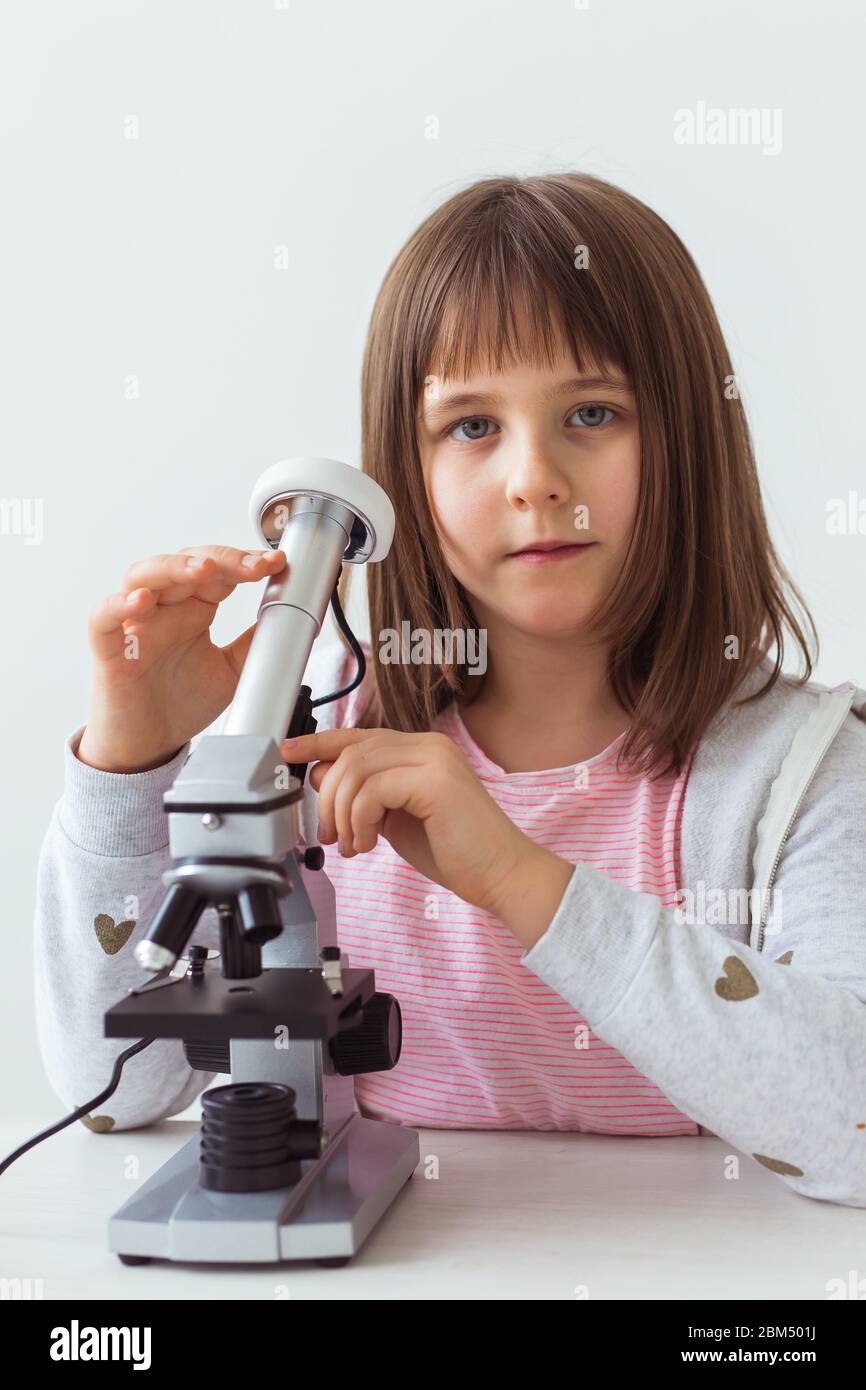 Child girl in science class using digital microscope. Technologies ...