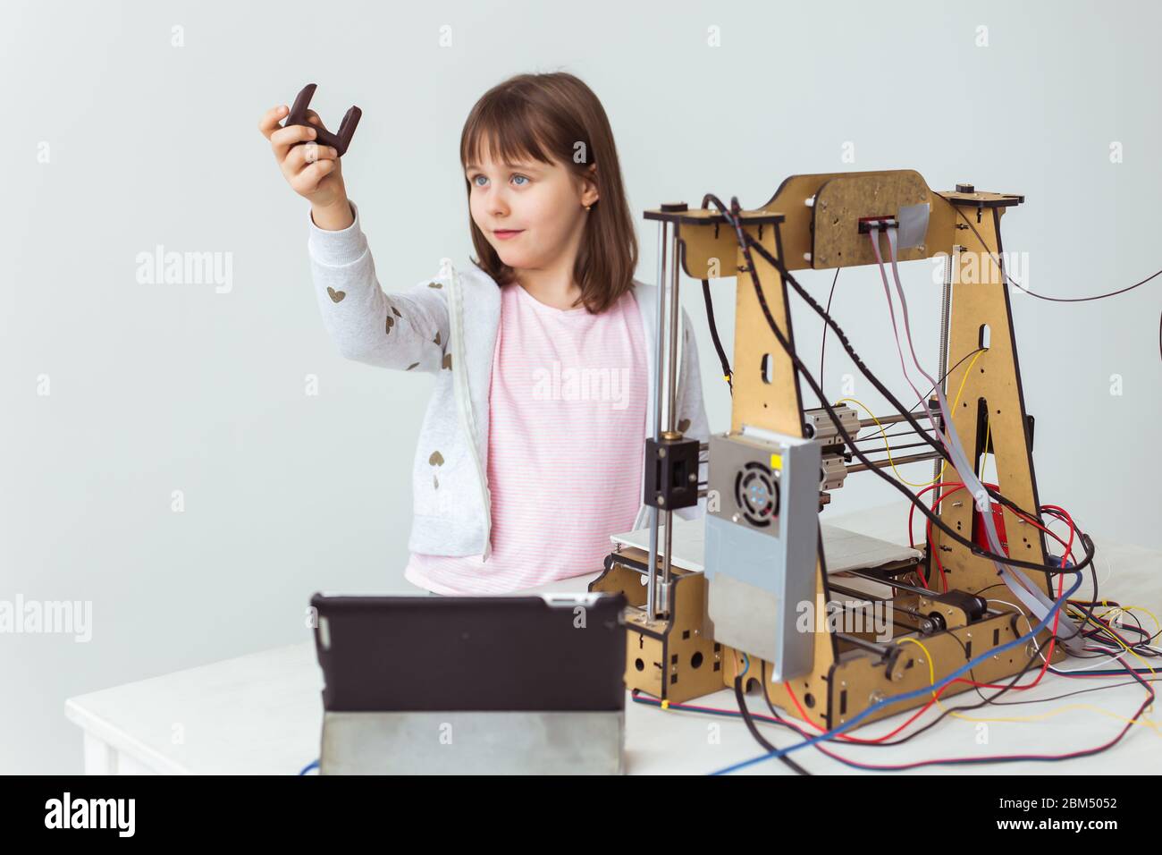 Cute girl with 3d printed shutter shades is watching her 3d printer as ...
