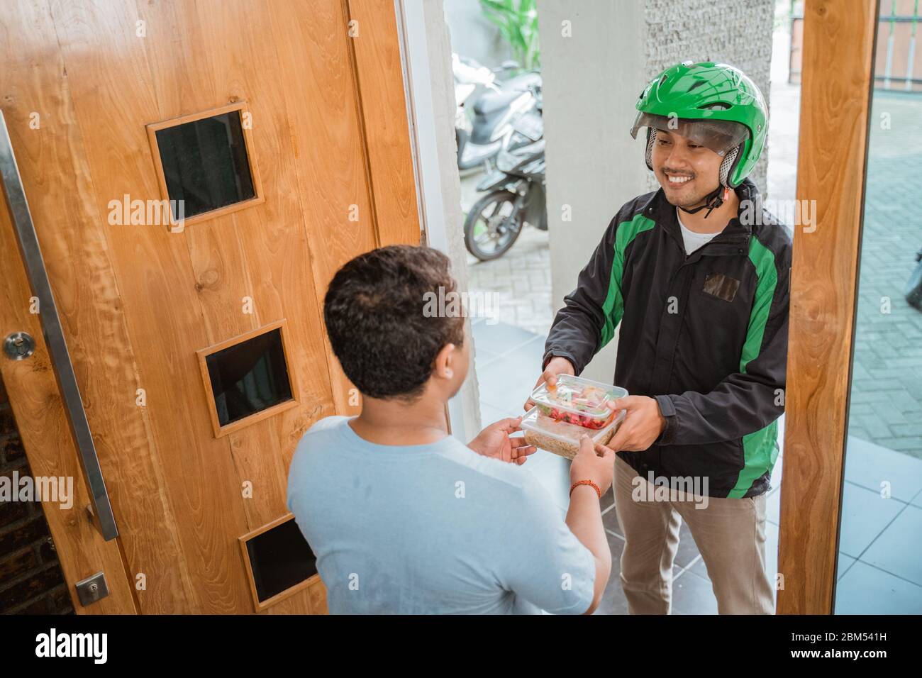 man ordering food online and receive the order at home delivered by ...