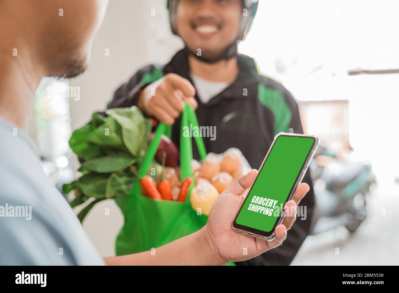 online grocery shopping. delivery man delivering food to a person at ...