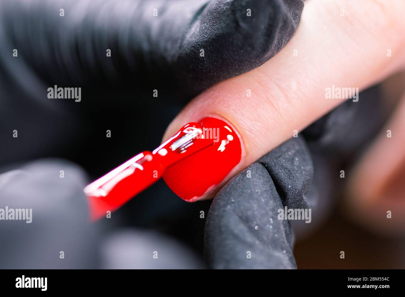 Master applied varnish drawing on nails gel in manicure salon, close-up ...