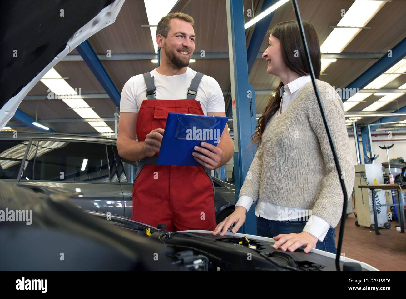 mechanic and customer talking in a workshop to repair a vehicle Stock ...