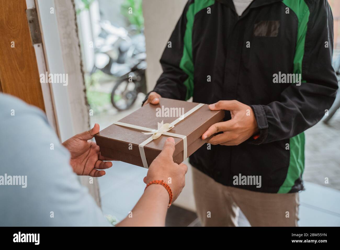 uber driver courier delivering gift box to a man in his house Stock ...