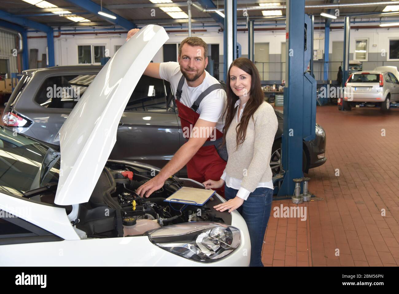 mechanic and customer talking in a workshop to repair a vehicle Stock ...