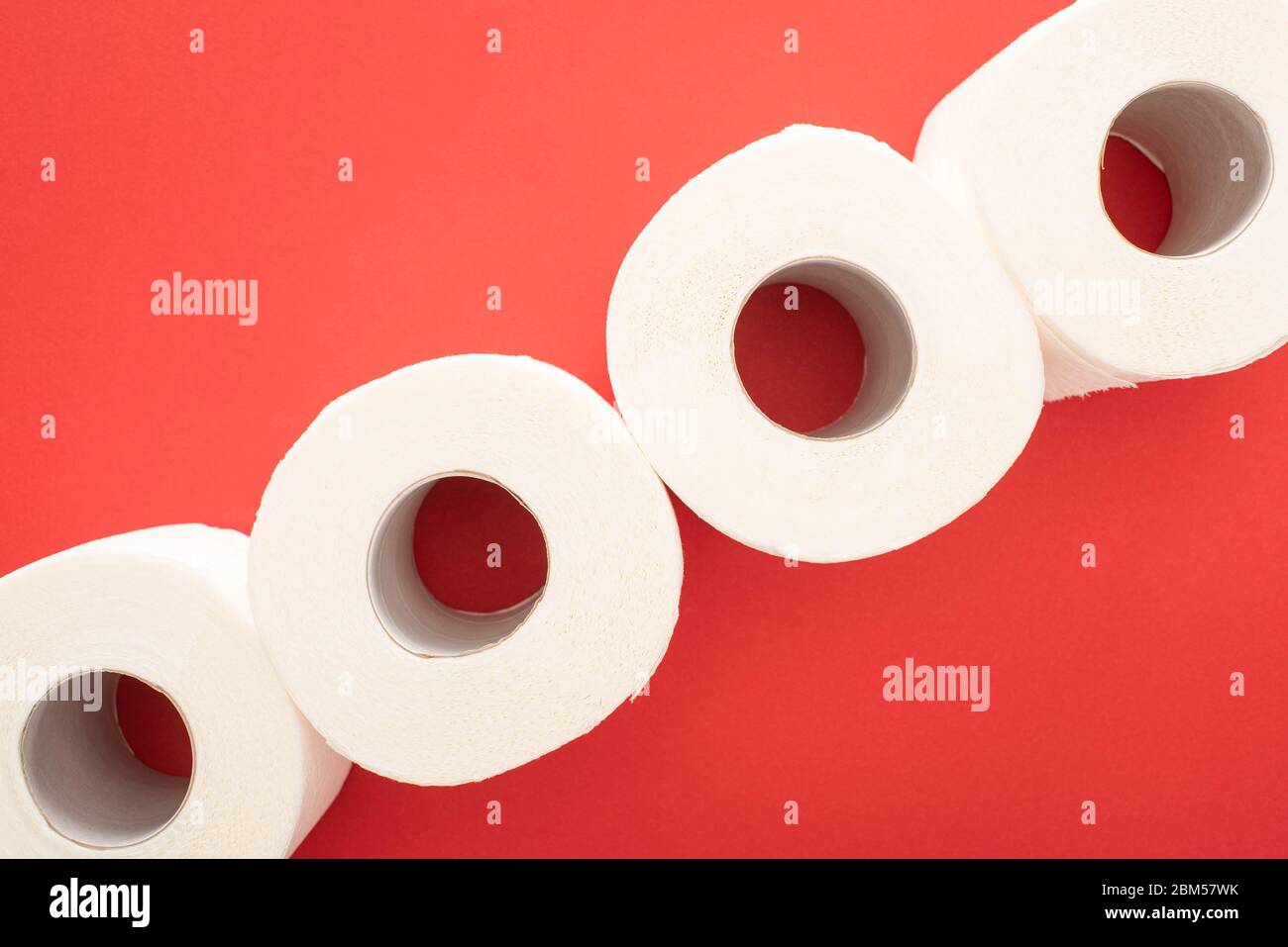 top view of white toilet paper rolls on red background Stock Photo - Alamy