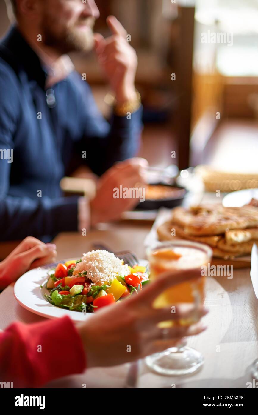 Hands view of young people eating brunch in trendy bar restaurant ...