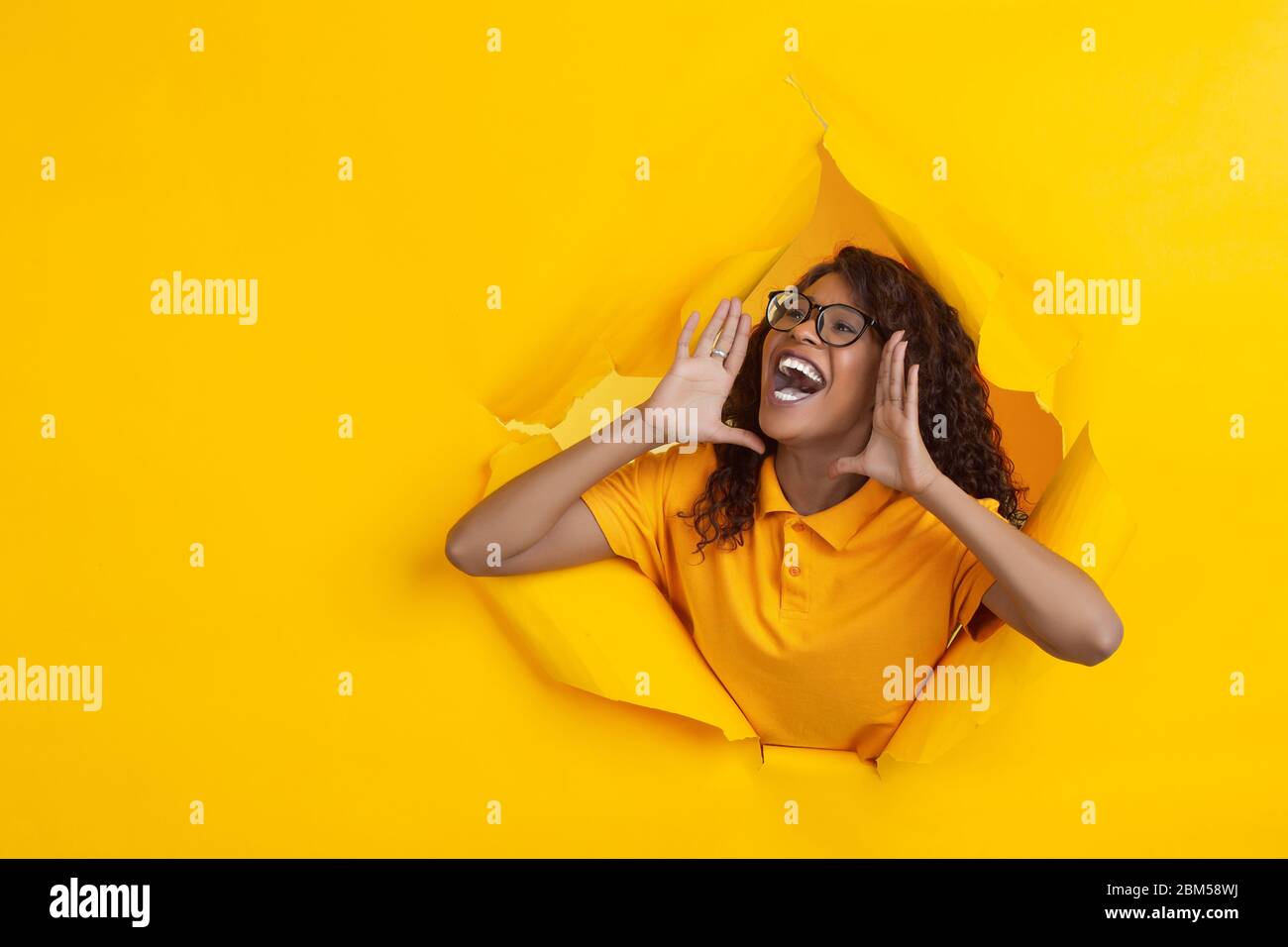 Astonished shouting. Cheerful african-american young woman in torn ...