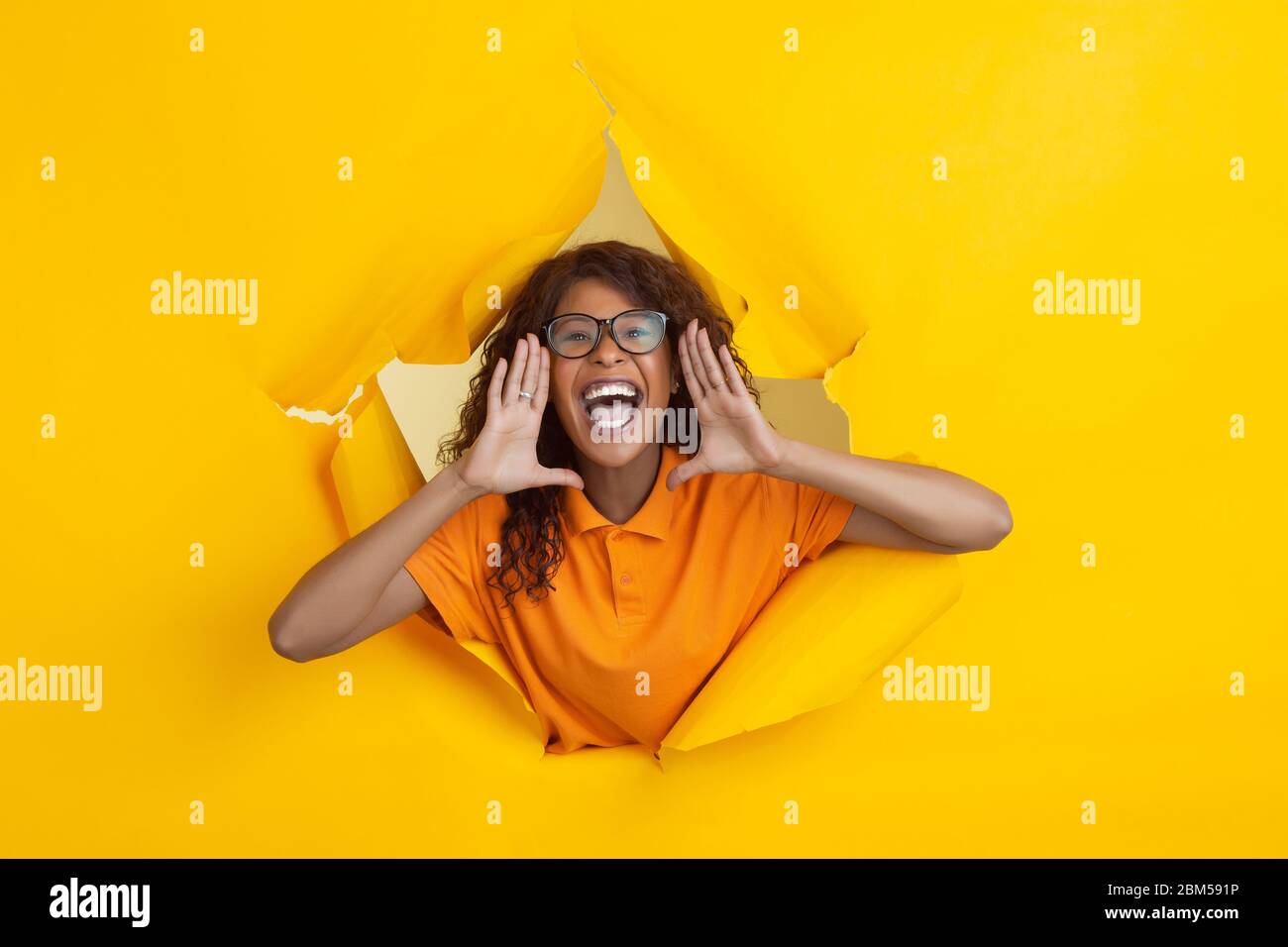 Astonished shouting. Cheerful african-american young woman in torn ...
