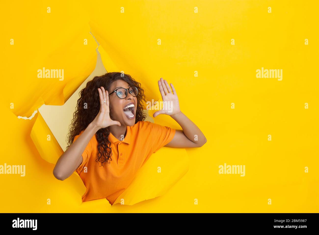 Astonished shouting. Cheerful african-american young woman in torn ...
