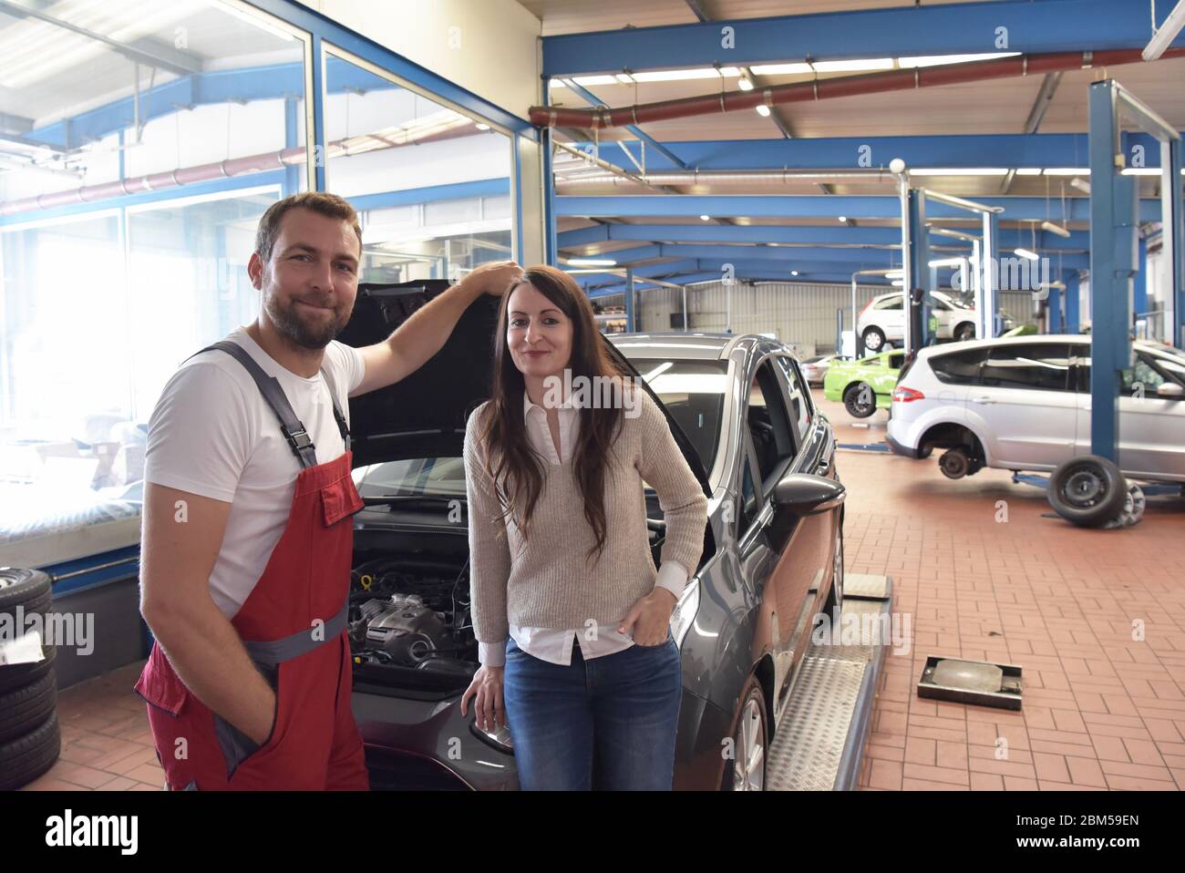 Customer service: car mechanic and customer discuss the repair of a ...