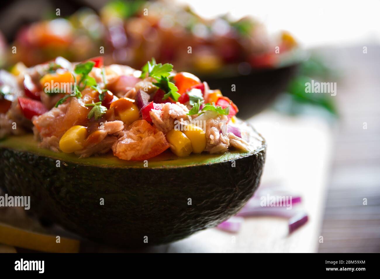 Avocado filled with tuna fish and vegetables Stock Photo - Alamy