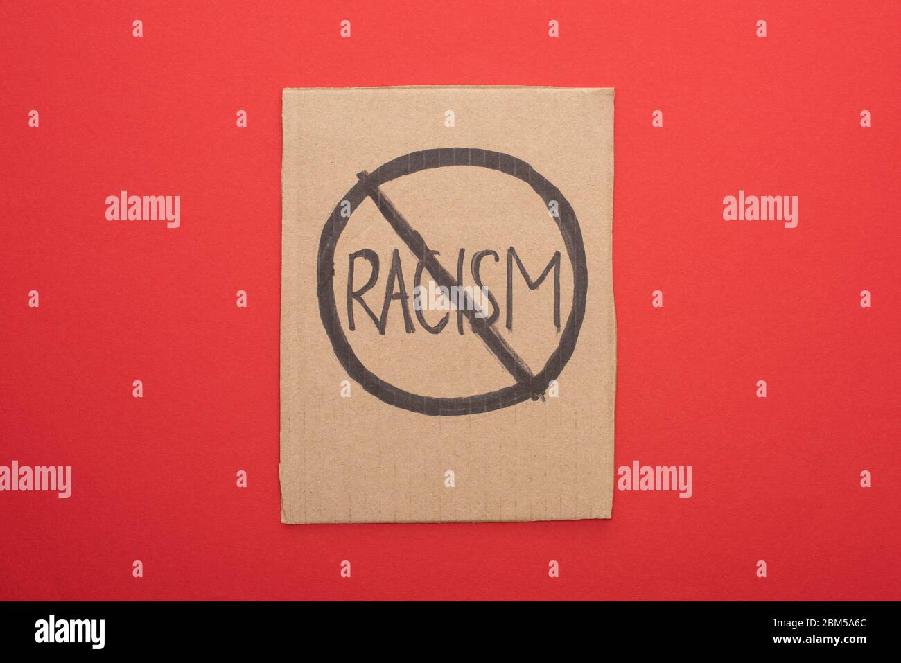 top view of carton placard with stop racism sign on red background ...