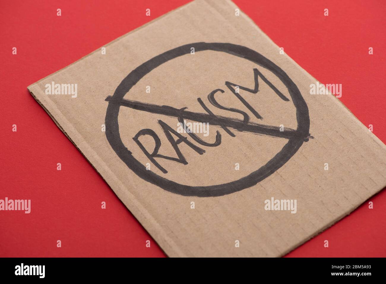 carton placard with stop racism sign on red background Stock Photo - Alamy