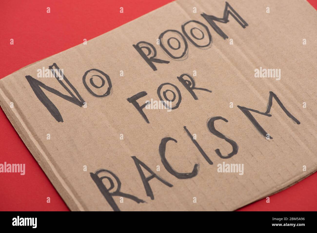 carton placard with say no room for racism lettering on red background ...