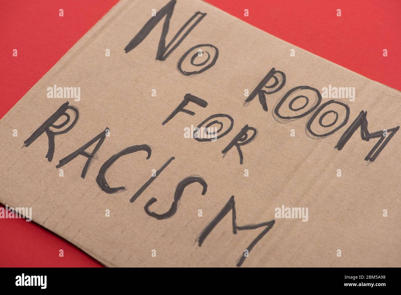 carton placard with say no room for racism lettering on red background ...