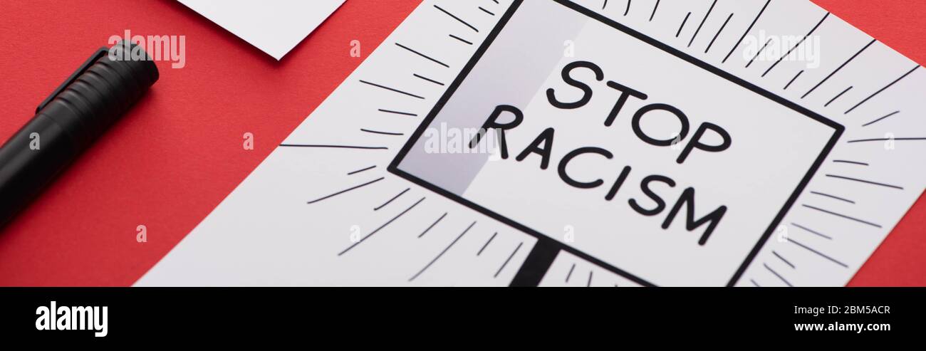 black marker and picture with drawn hand and stop racism placard on red ...