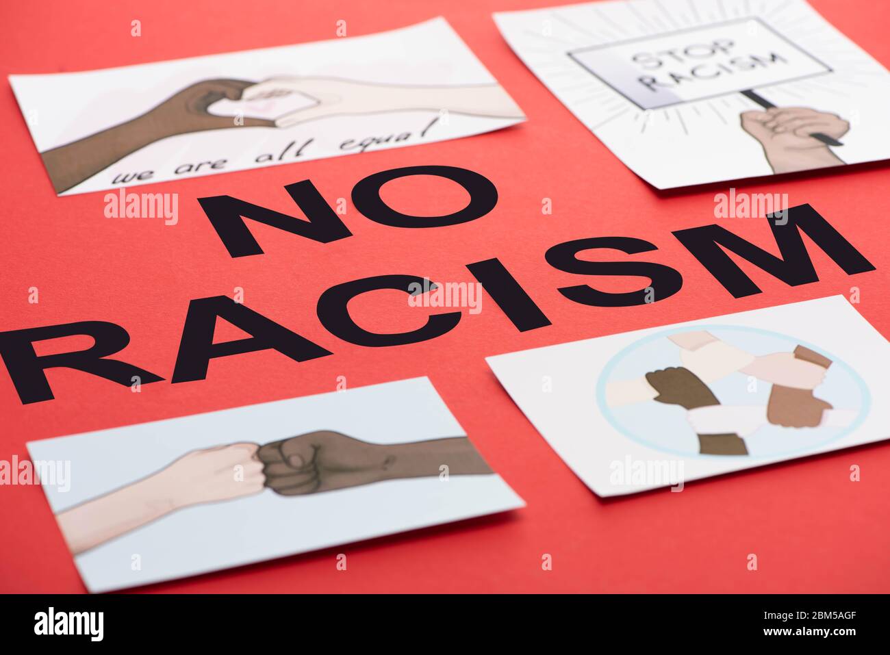 black no racism lettering among pictures with multiethnic hands on red ...