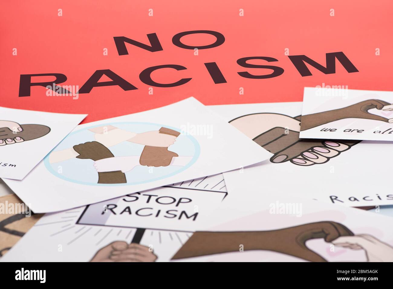 black no racism lettering among pictures with multiethnic hands on red ...