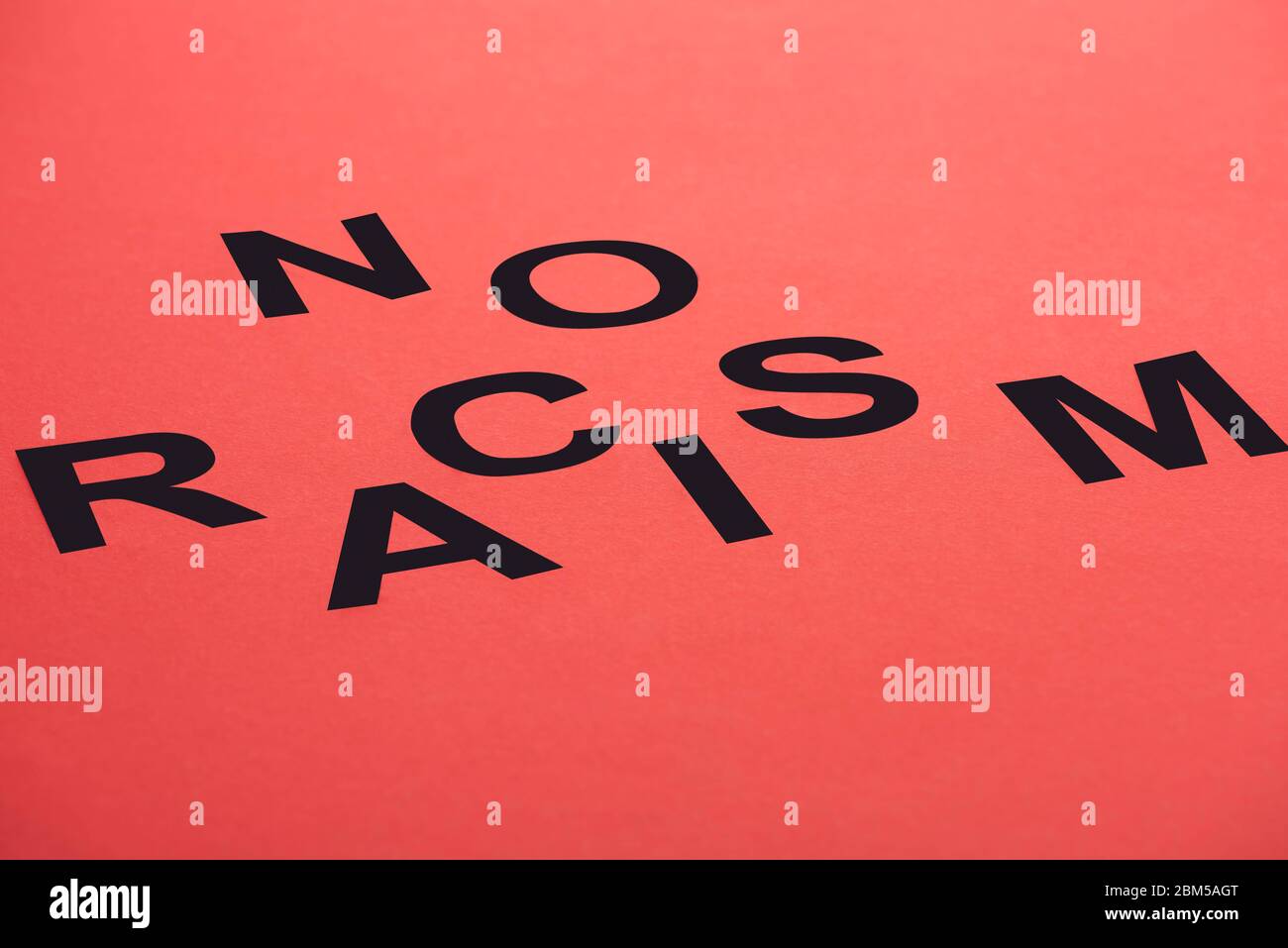 black no racism lettering isolated on red Stock Photo - Alamy