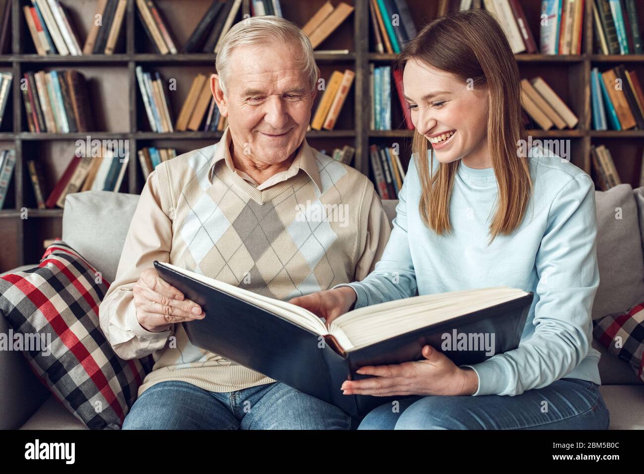 Father and daughter at home library sitting reading book cheerful Stock ...