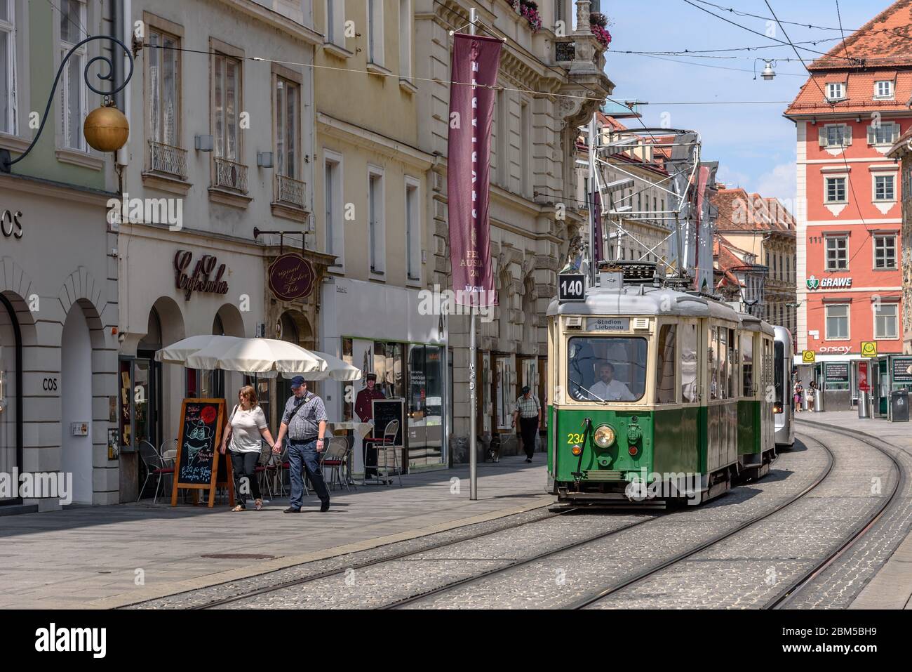 An old tram going through the old town of Graz, Austria on a summer day ...