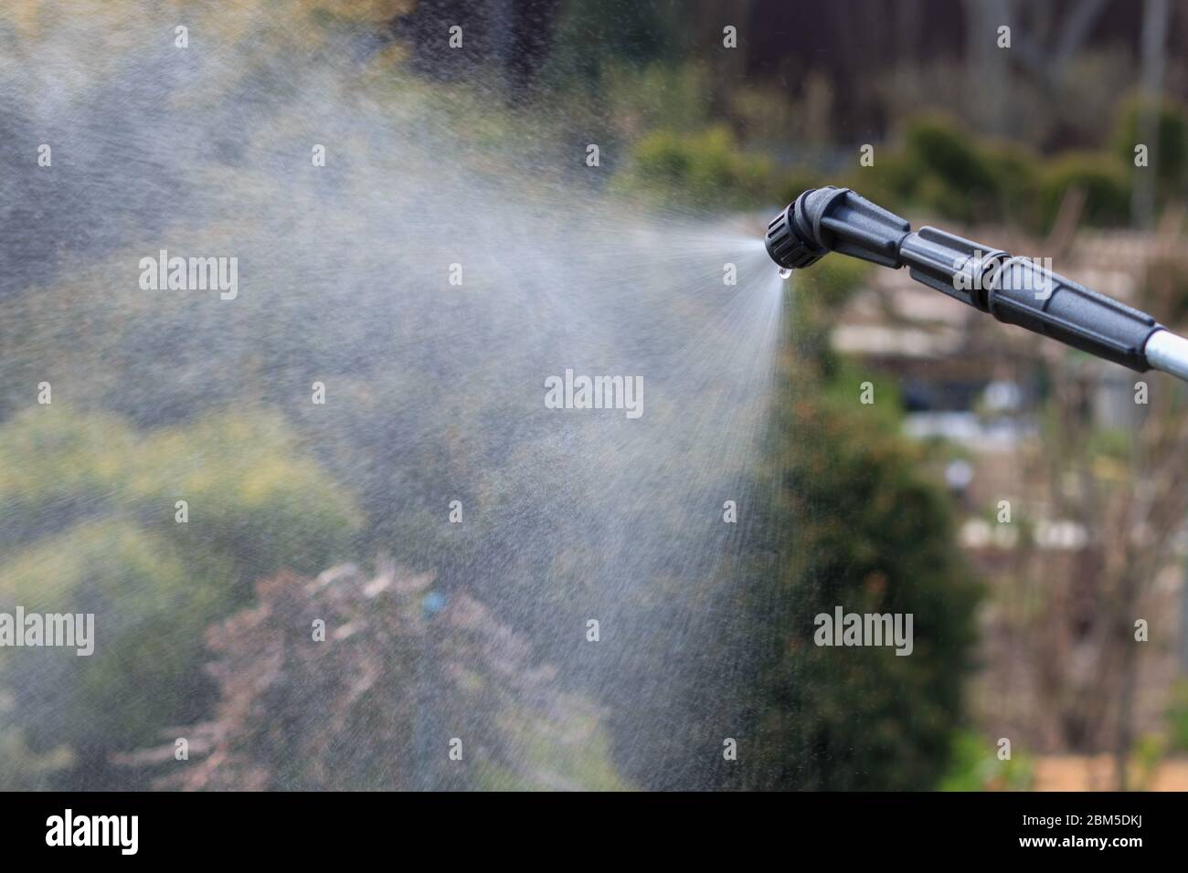 spraying pesticide with a special device in the garden, a number of ...