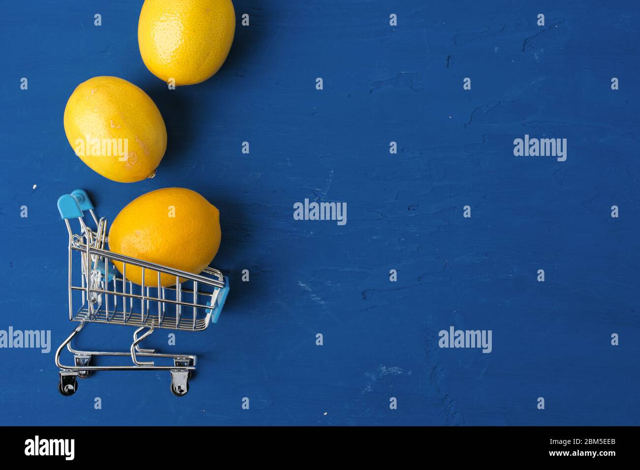 Lemon in shopping cart on classic blue background, top view Stock Photo ...