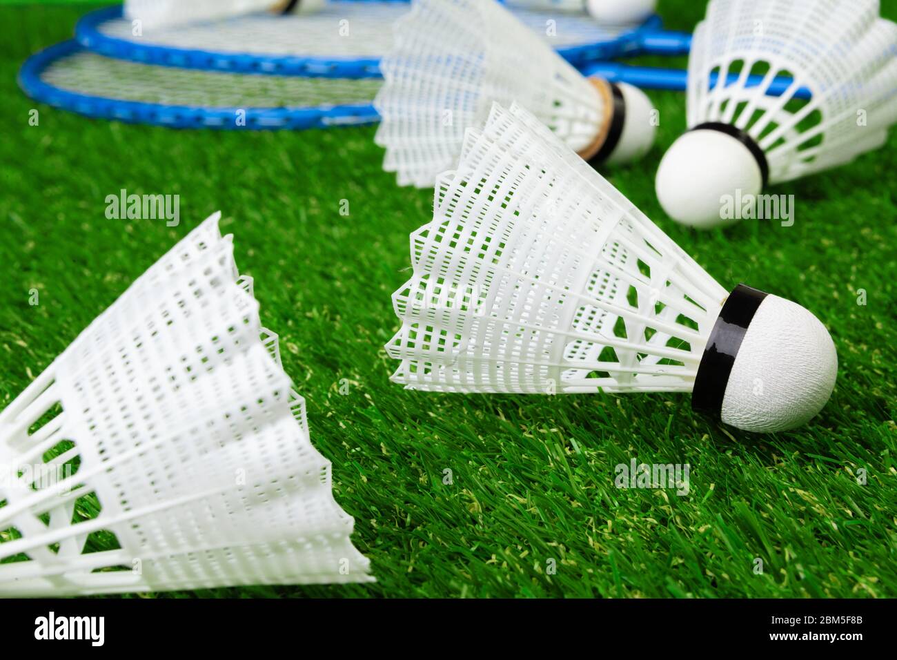 Badminton game rackets and shuttlecock on grass Stock Photo - Alamy