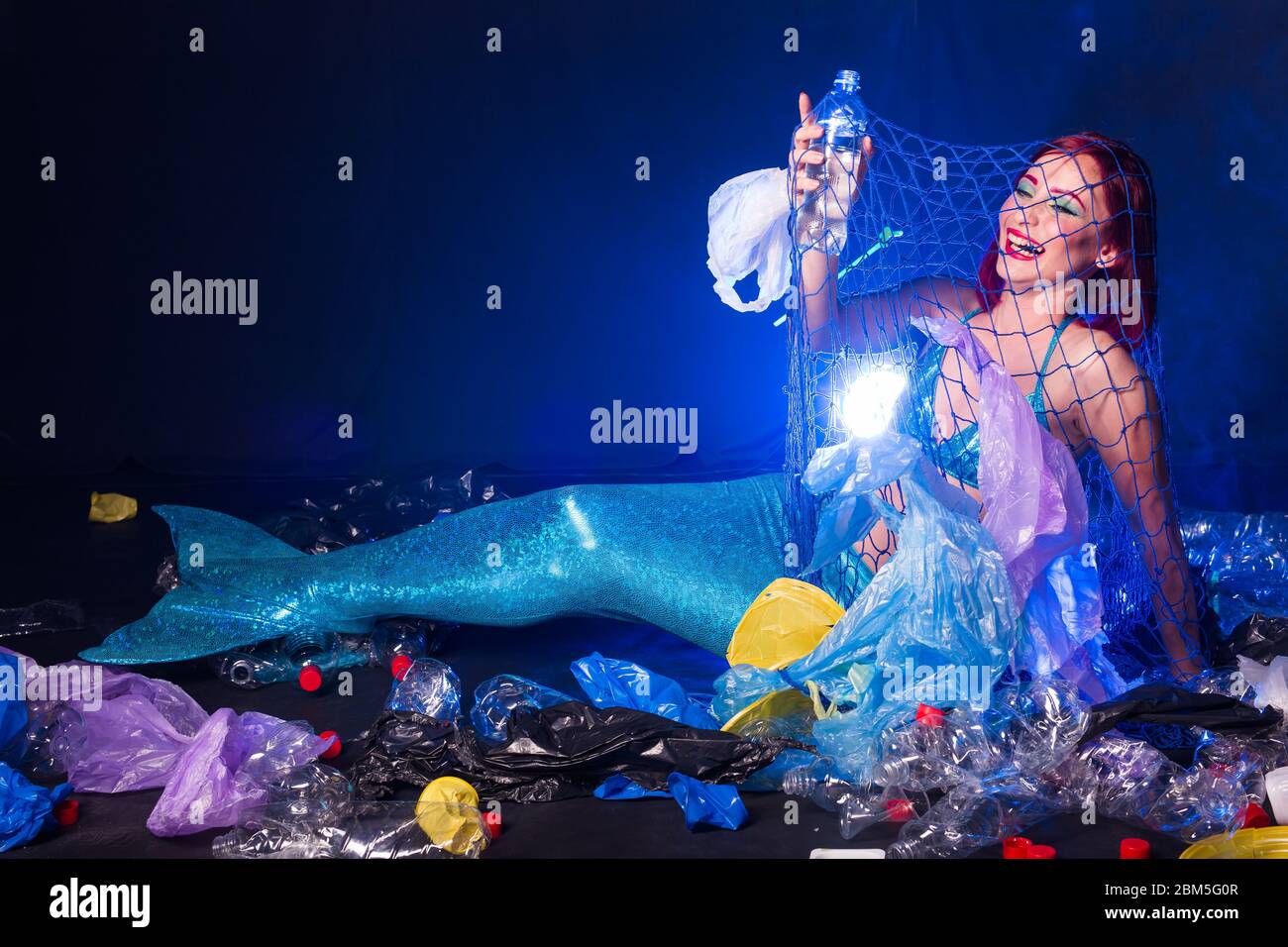 Ocean plastic pollution. Mermaid have fun in water with plastic garbage ...