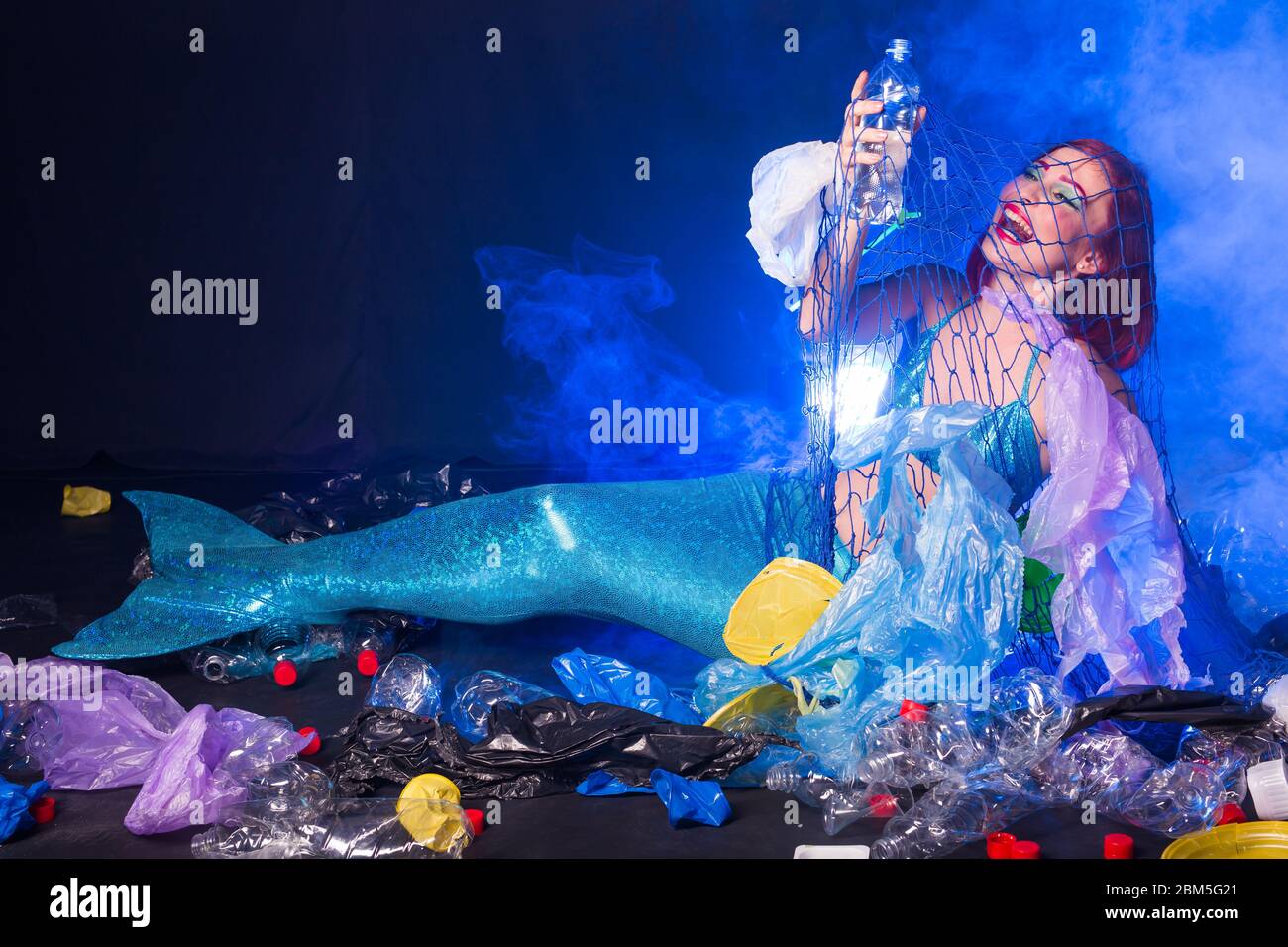 Fantasy stupid mermaid in deep ocean. Plastic water bottles and bags ...