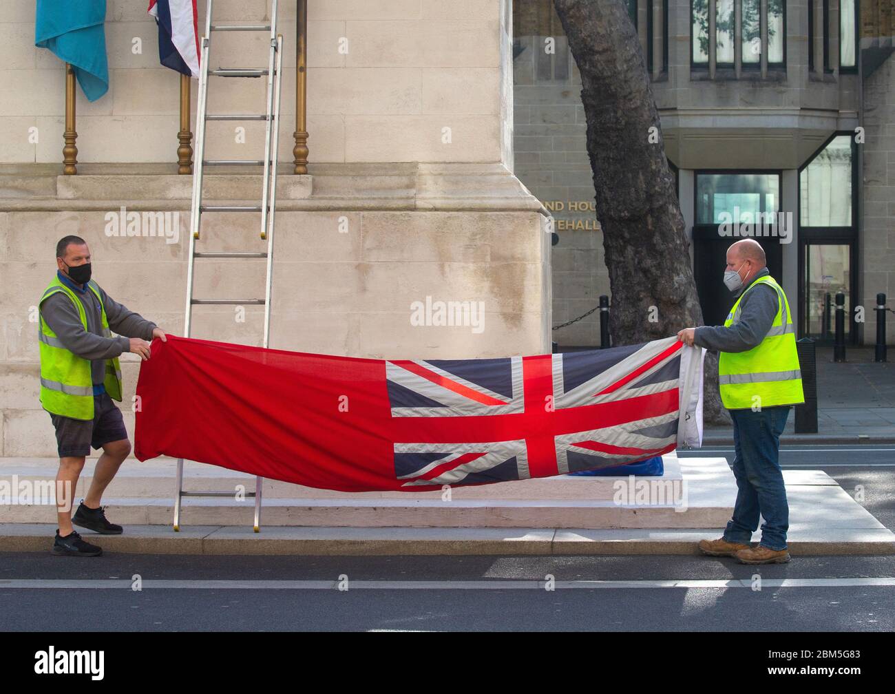 London, UK. 7th May, 2020. Workmen change the flags on the Cenotaph in ...